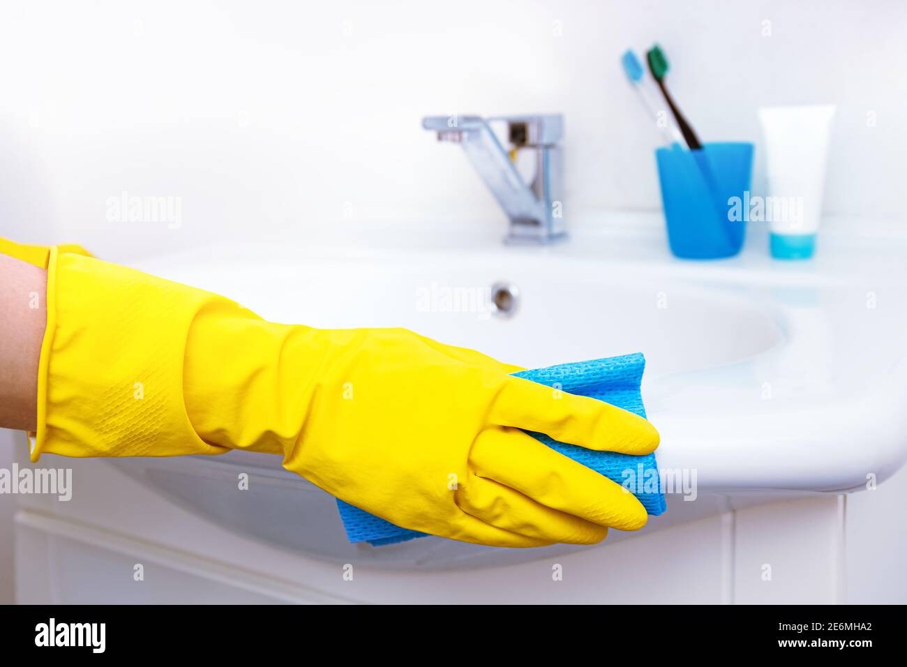 Clean up your house. Woman doing chores in bathroom, hands in yellow ...