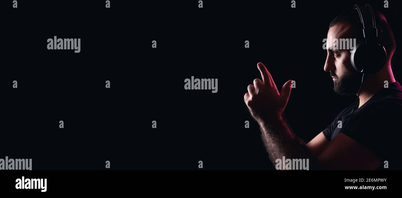 Bearded young Arab DJ musician listens music with headphones and ...