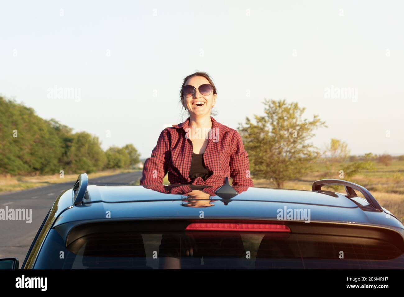 Travelling by car. The girl looks out of the car hatch. young woman ...