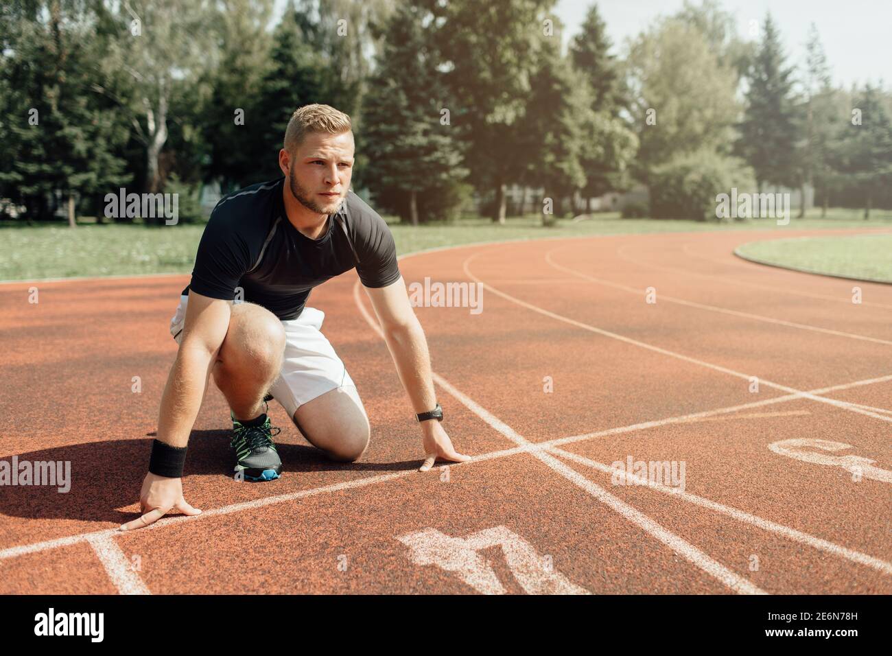 Focused male runner at starting position Stock Photo - Alamy