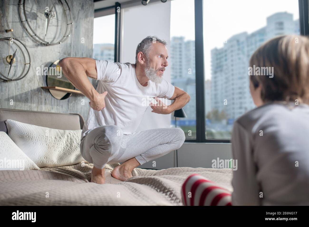 Dad making movement and grimacing child watching Stock Photo - Alamy