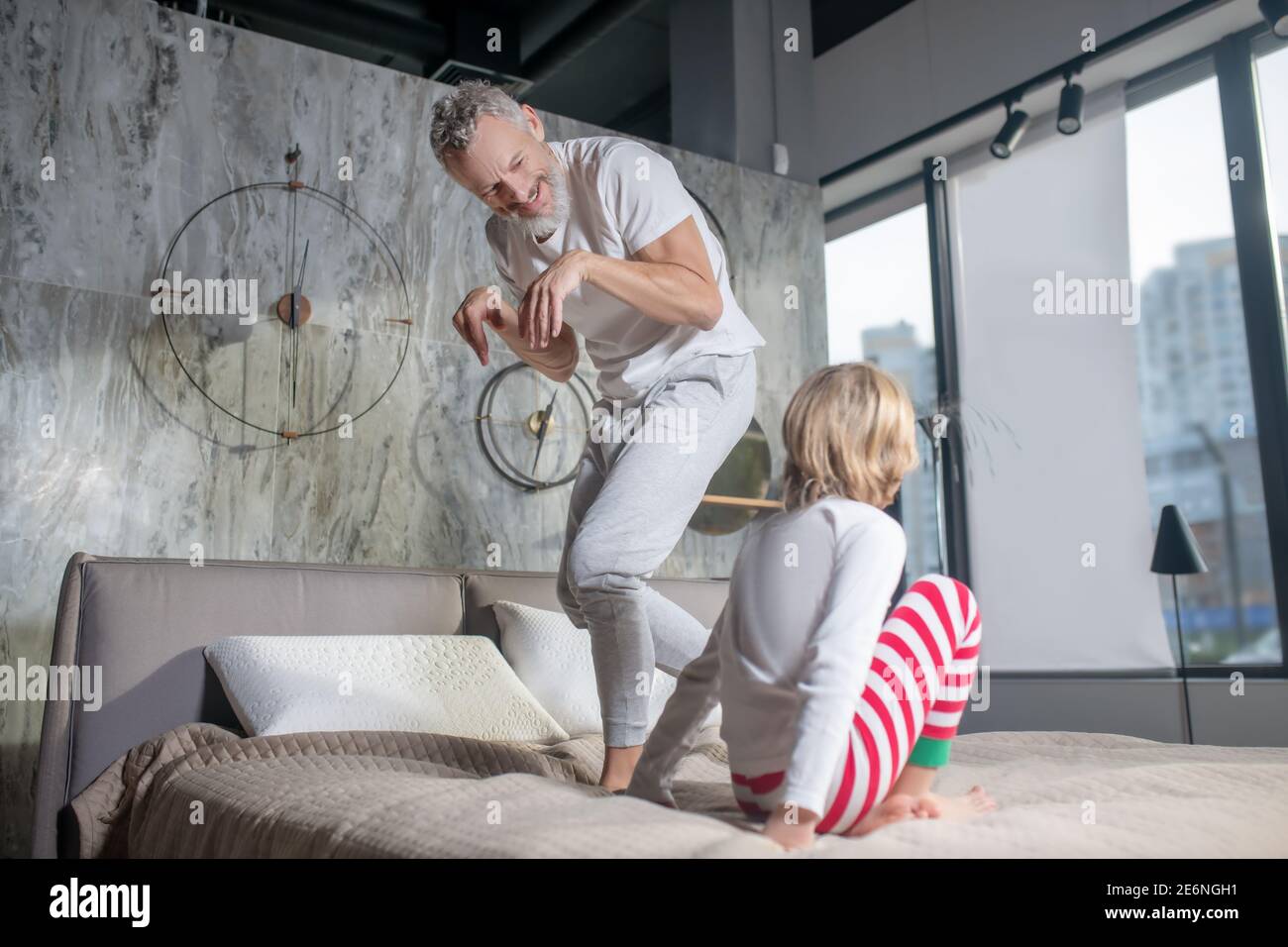 Dad entertaining baby on bed at home Stock Photo - Alamy