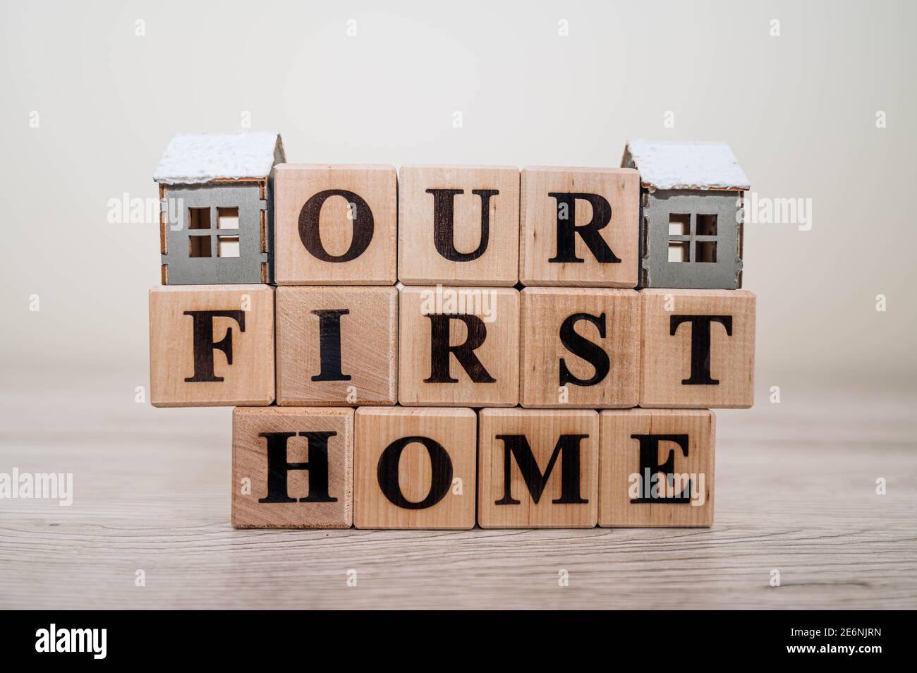 Text OUR FIRST HOME on wood cube blocks. The letters OUR FIRST HOME ...