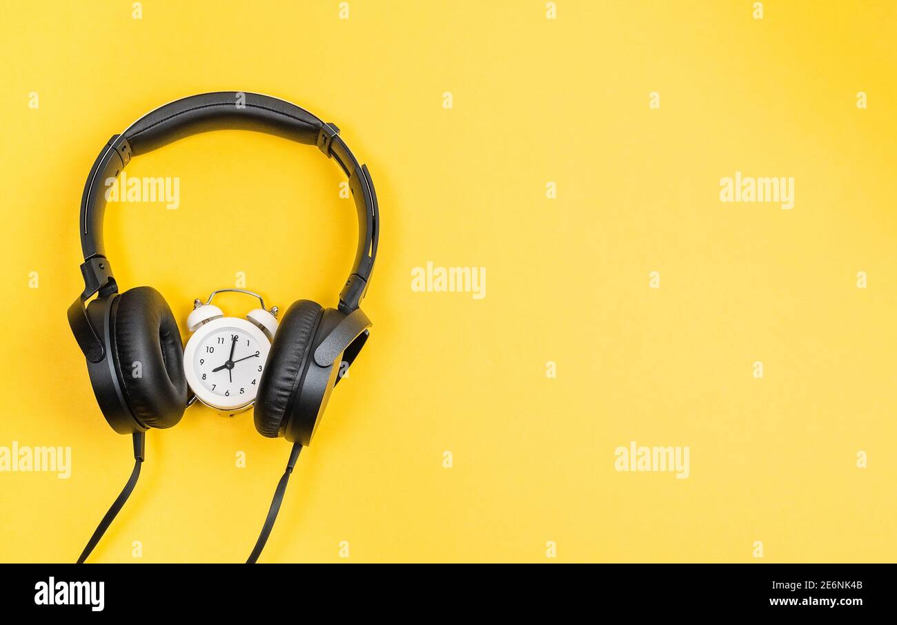time to listen to music alarm clock and headphones on a yellow ...