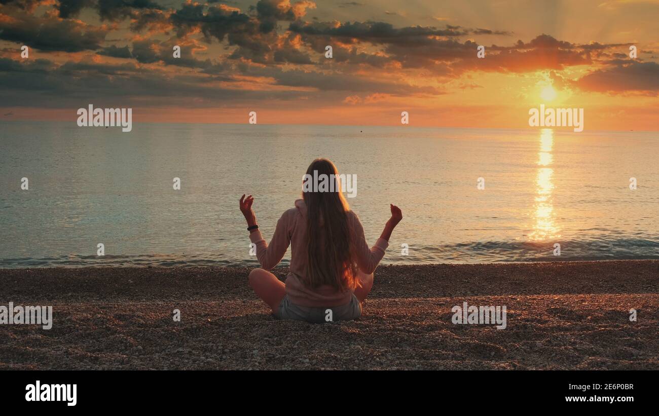 Back view woman meditating on the beach hi-res stock photography and ...