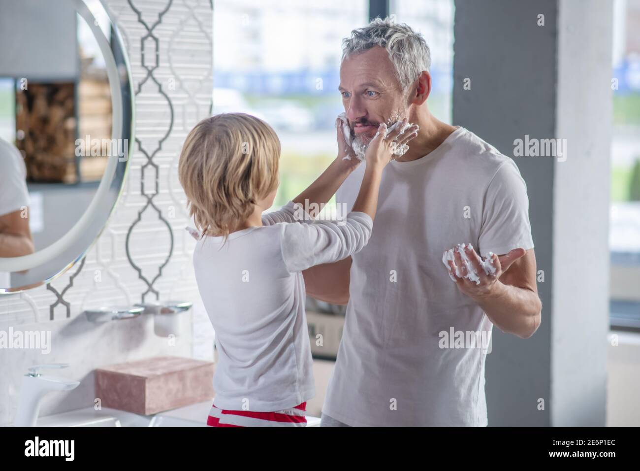 Surprised dad and child smearing with soap suds Stock Photo - Alamy