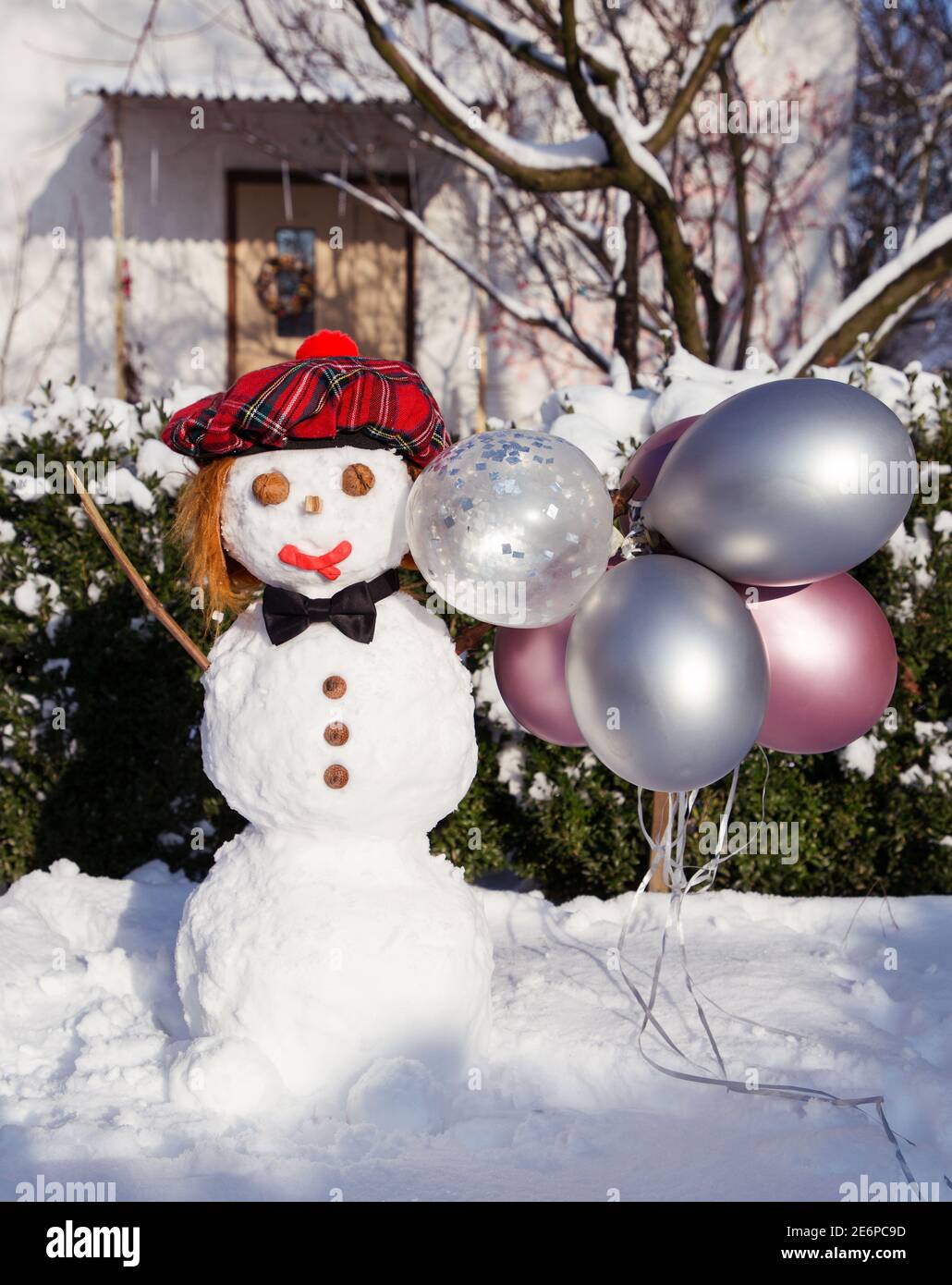 happy snowman in bright red beret and sunglasses, holding several air ...