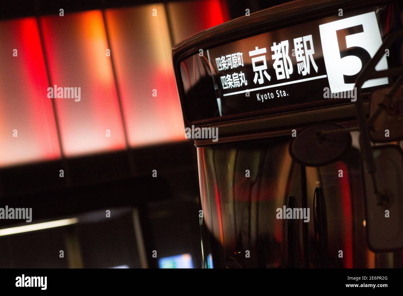 Number 5 bus at Kyoto Train Station reflects colored lights at night ...