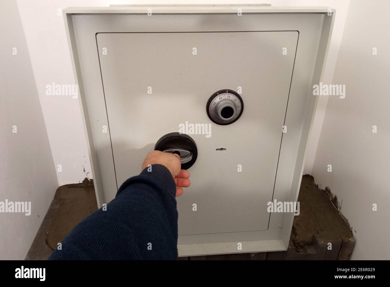 Installing a safe in the house, the master makes measurements to ...