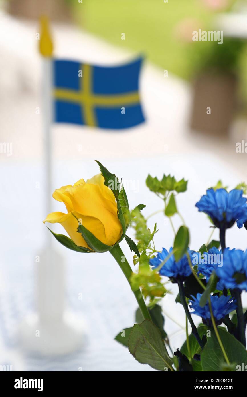 MOTALA, SWEDEN- 9 JUNE 2020:Swedish flag and blue-yellow flowers on a ...