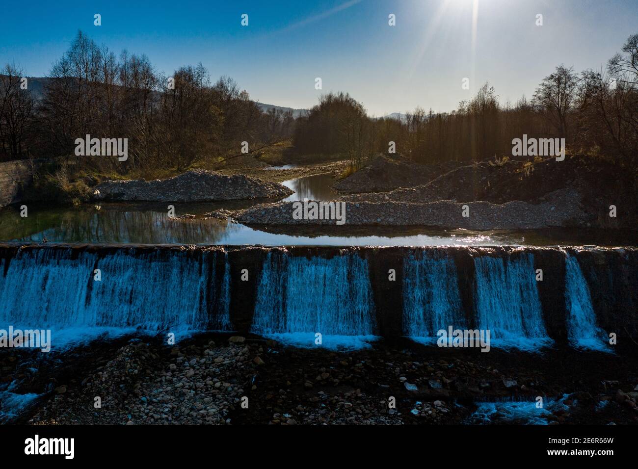 runoff on a small man-made dam, rural autumn landscape, calm lake water ...