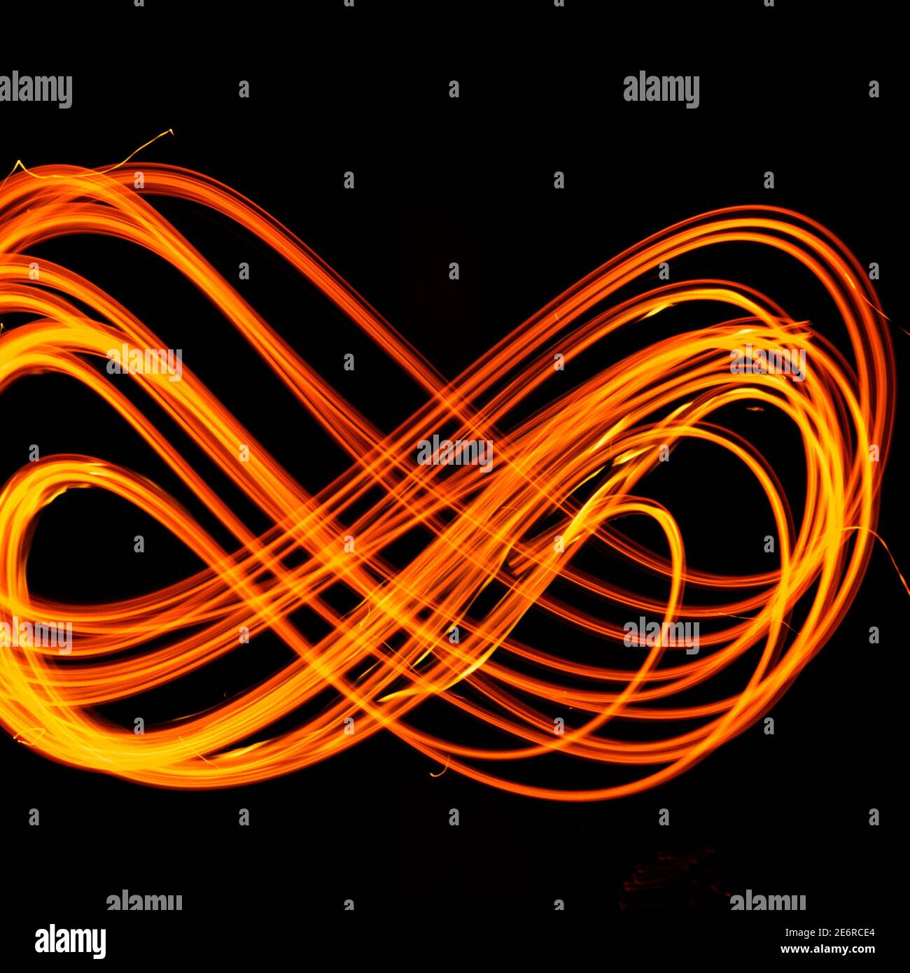 Drawing shapes with fire at night, infinity sign, bright colors on ...