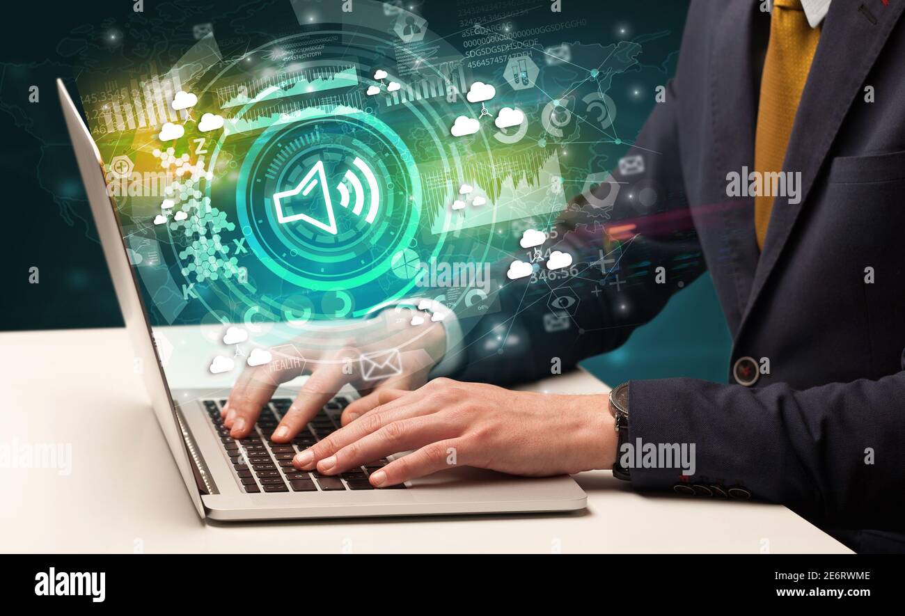 Business hand typing on a modern laptop with loud sound icon coming out ...