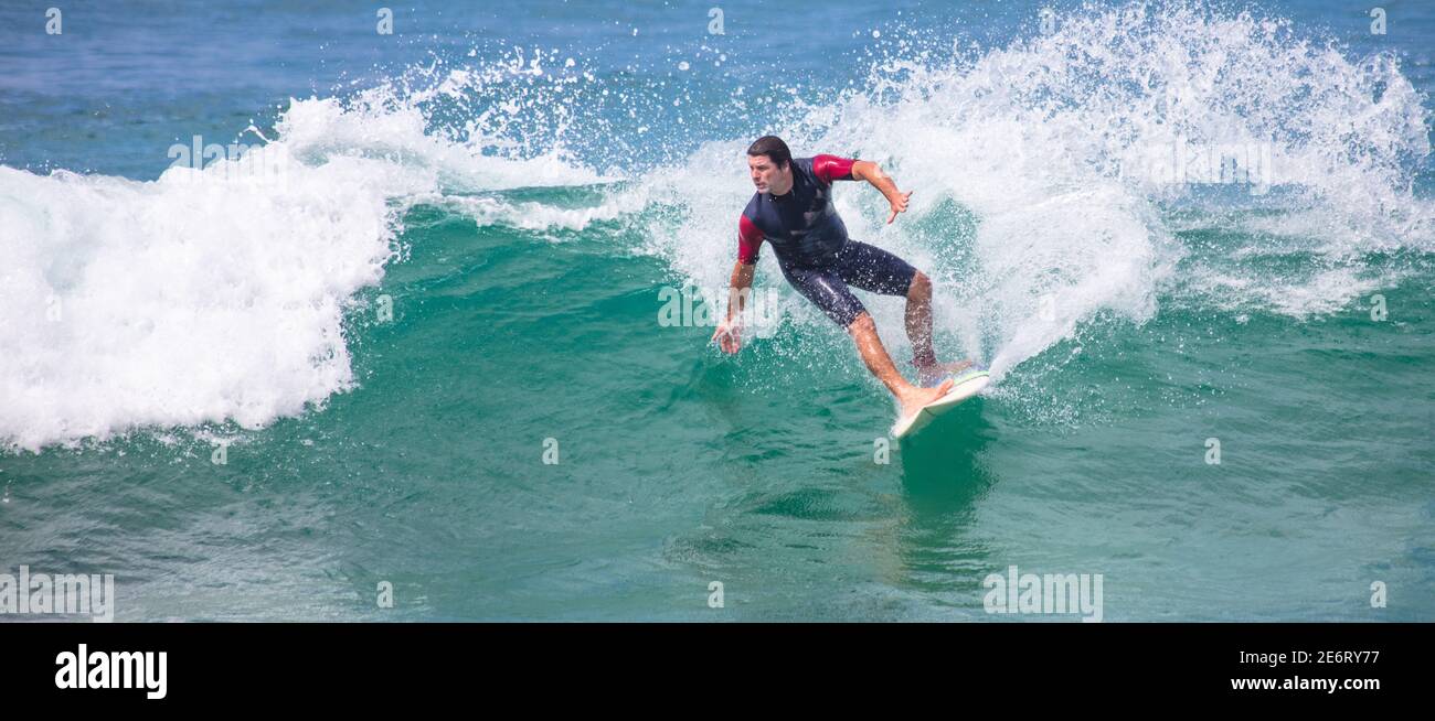 Handsome surfer catching the wave Stock Photo - Alamy