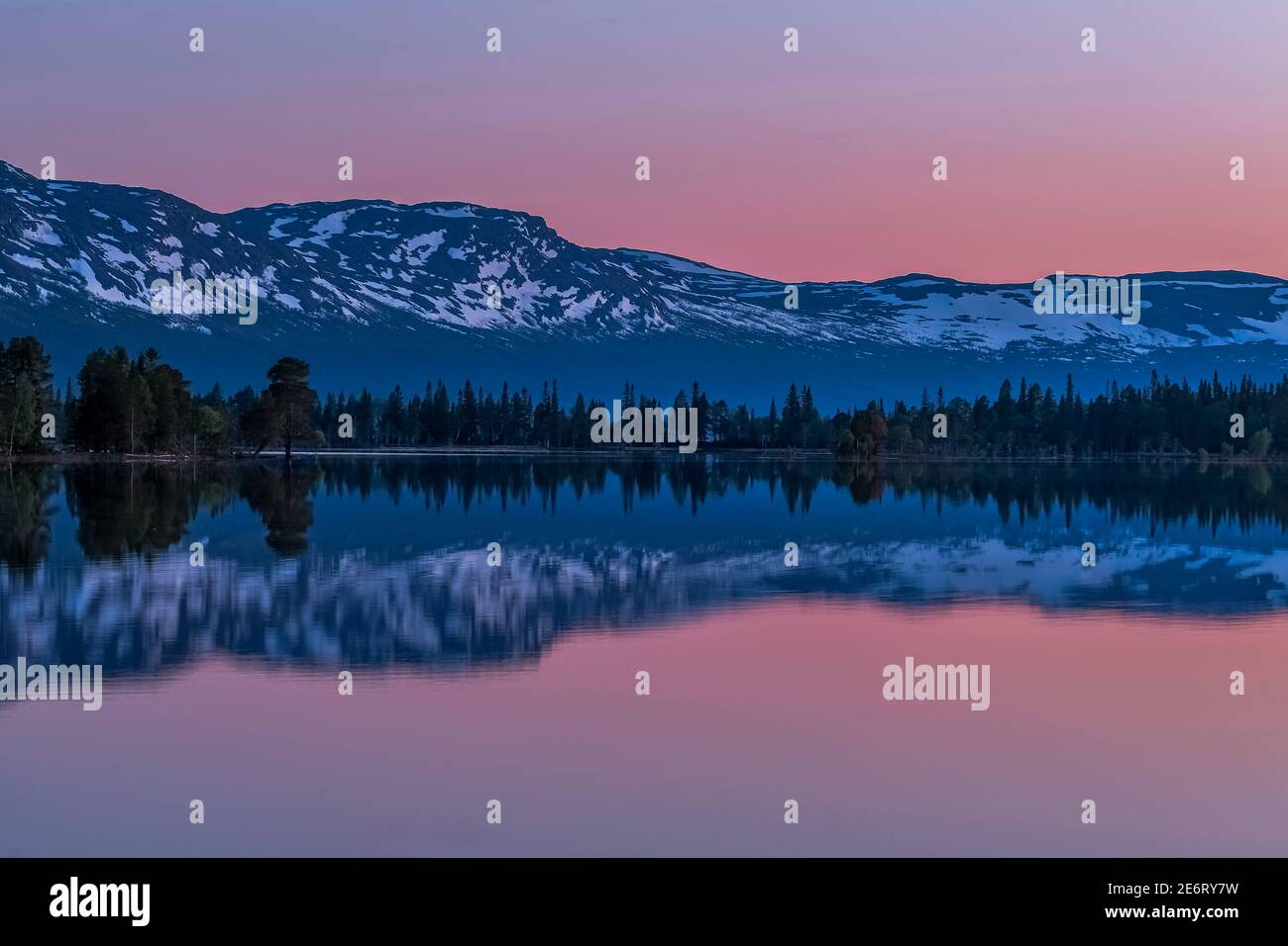 Mesmerizing sunset view of mountains and trees reflecting in the lake ...
