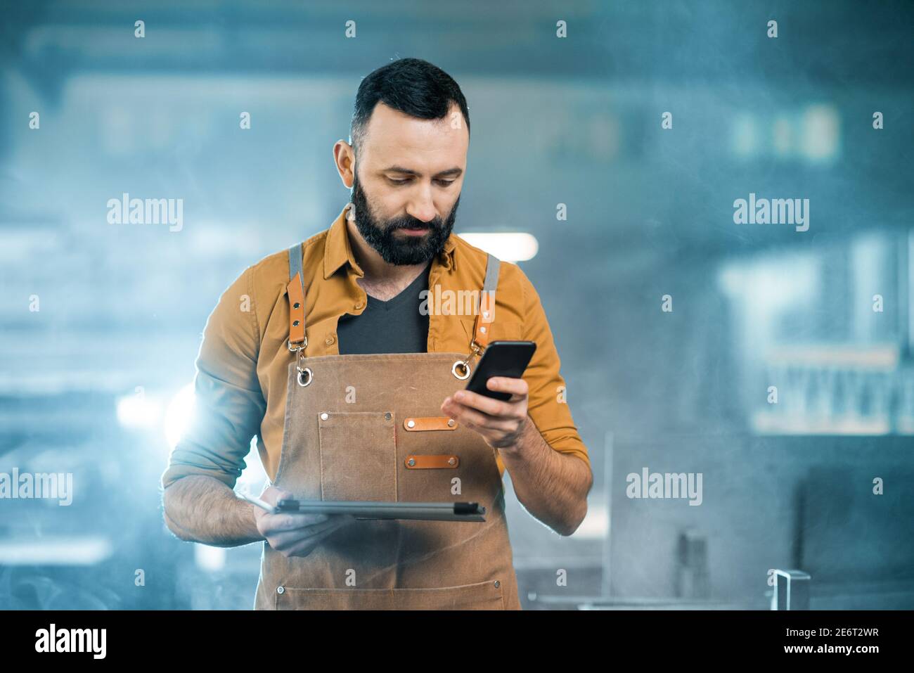 Factory worker with tablet and phone at the manufacturing Stock Photo ...