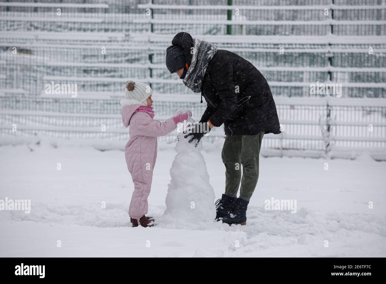 Mother and children make a snowman Stock Photo - Alamy