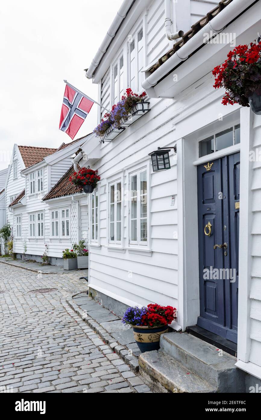 Houses with white wooden cladding with a norwegian flag in the old town ...