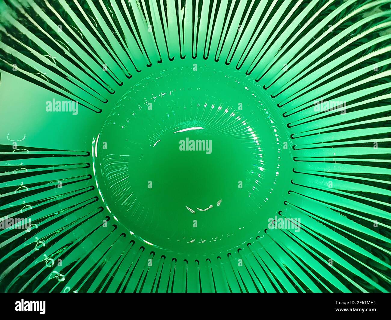 Abstract blurred background shot through thick green glass with shiny ...