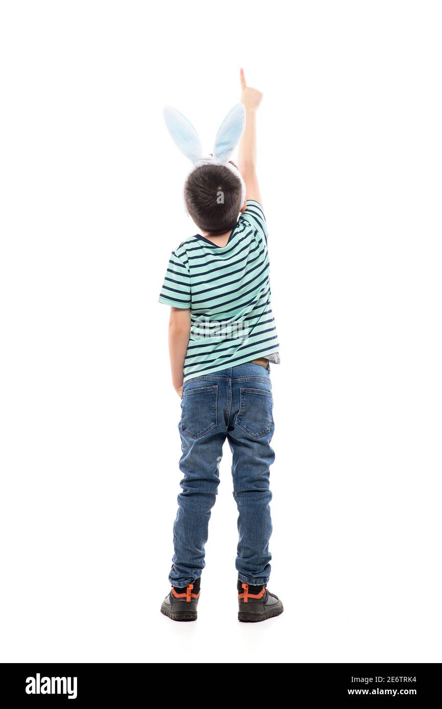 Behind view of young boy with Easter bunny ears showing direction ...