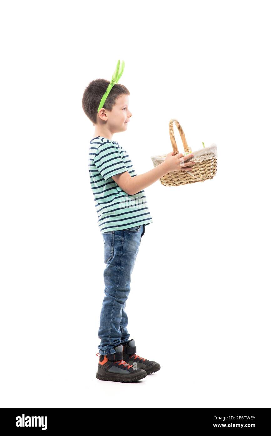 Side view of happy boy giving away basket full of Easter eggs hunt ...