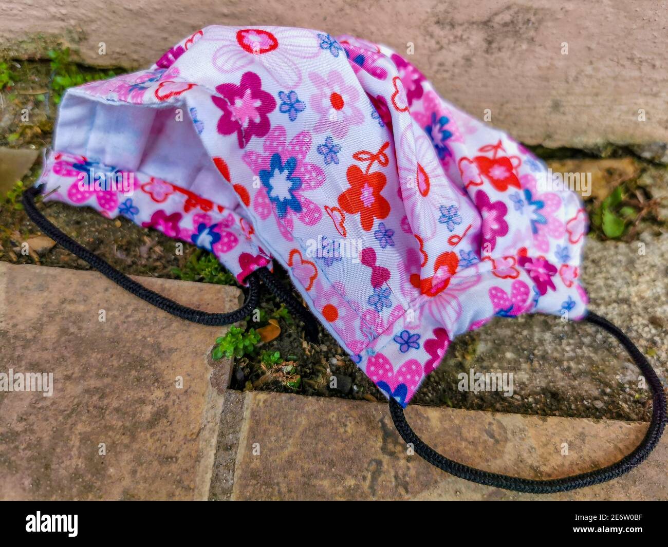 Dirty surgical pink masks with flowers on the ground. Corona virus ...
