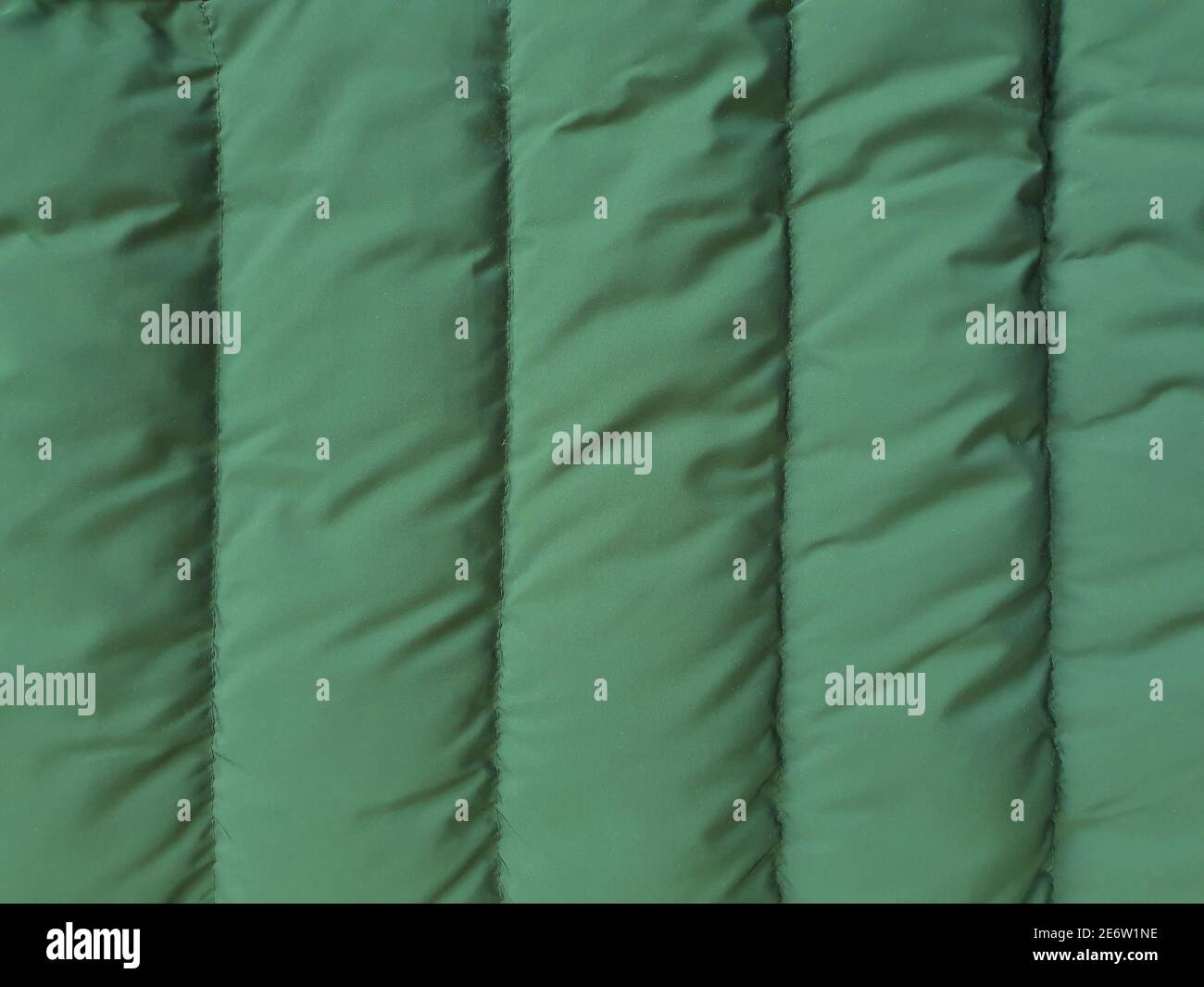 Down jacket fabric background, green puffer jacket texture. Top view ...