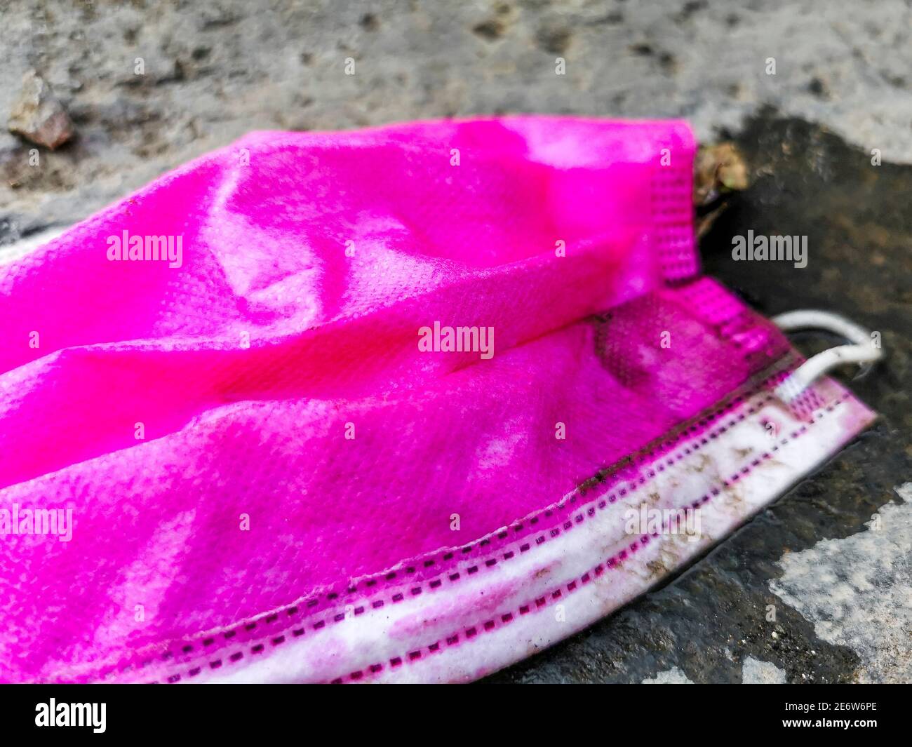 Dirty surgical pink masks on the ground. Corona virus pollution ...