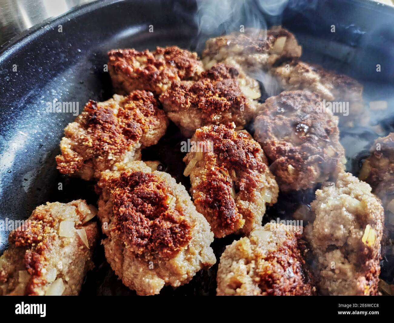 View to a pan with homemade traditional Berlin meatballs, with smoke ...