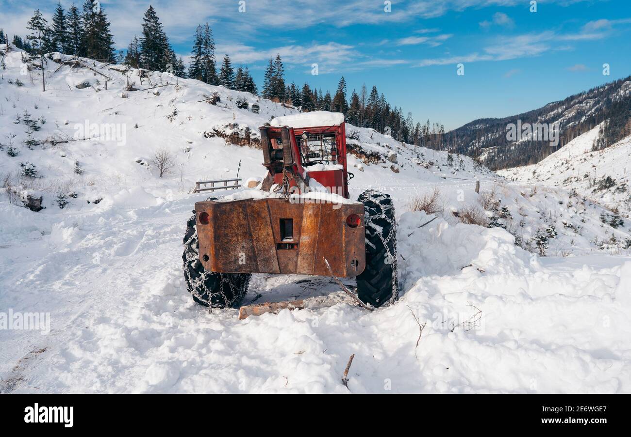 Winter scene in Europe, old tractor under the snow. Old Red farm ...