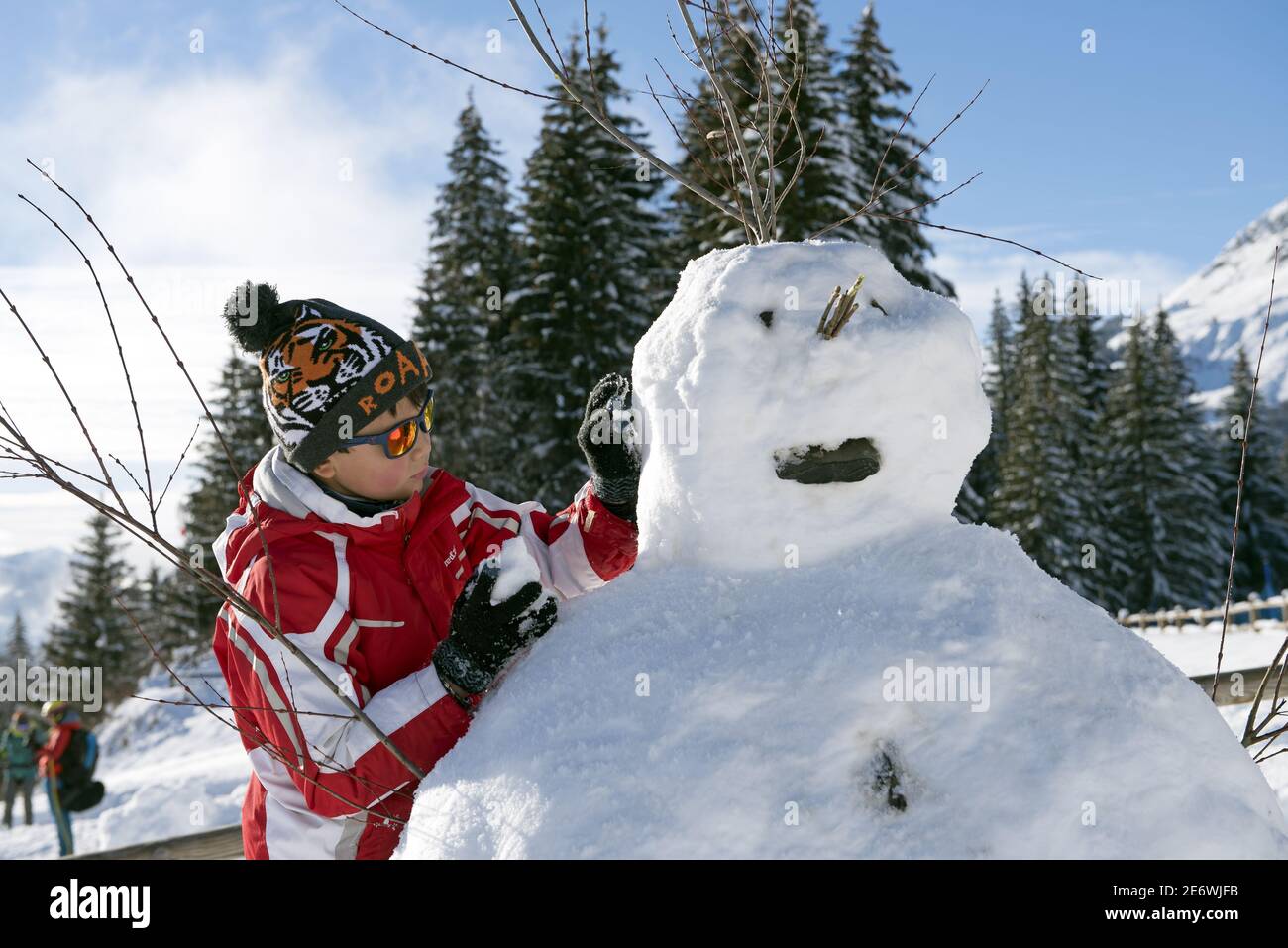 Boy making a snowman Stock Photo - Alamy