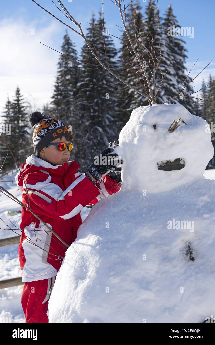 Boy making a snowman Stock Photo - Alamy