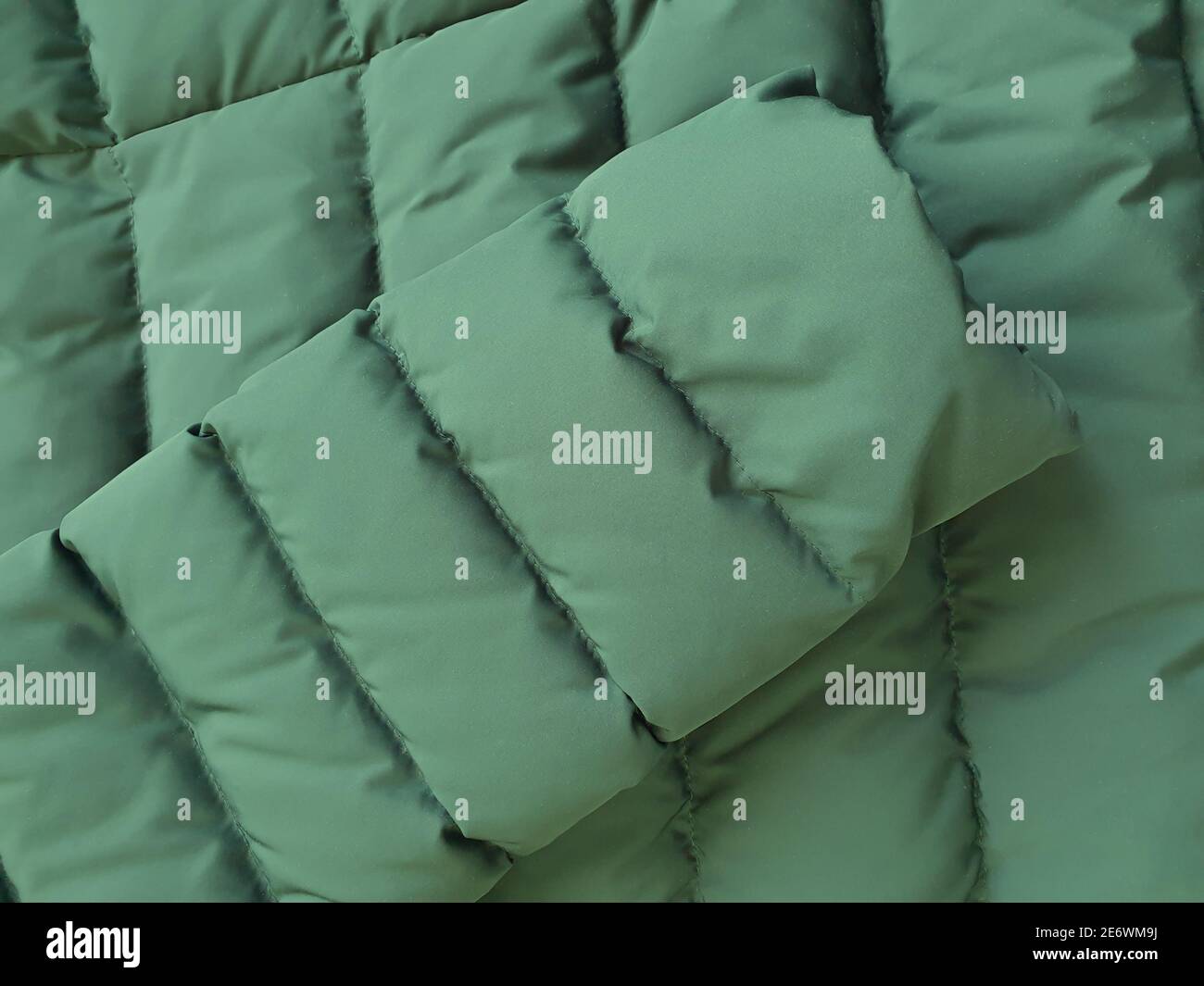 Down jacket sleeve and fabric background, green puffer jacket texture ...