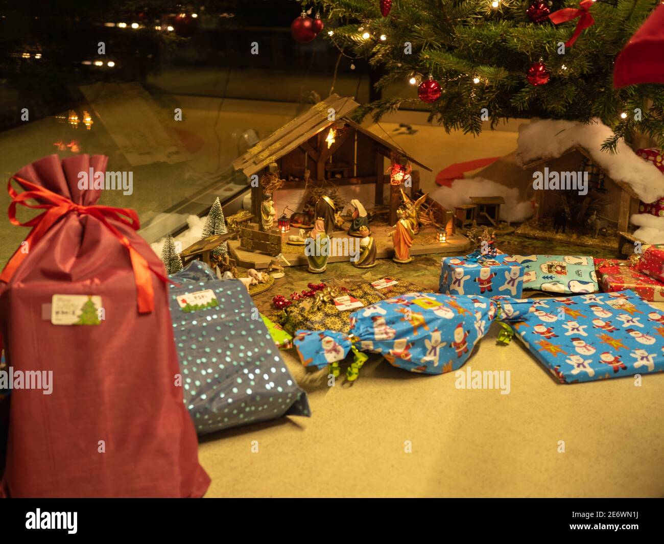 Creche in front of christmas tree with gifts Stock Photo - Alamy