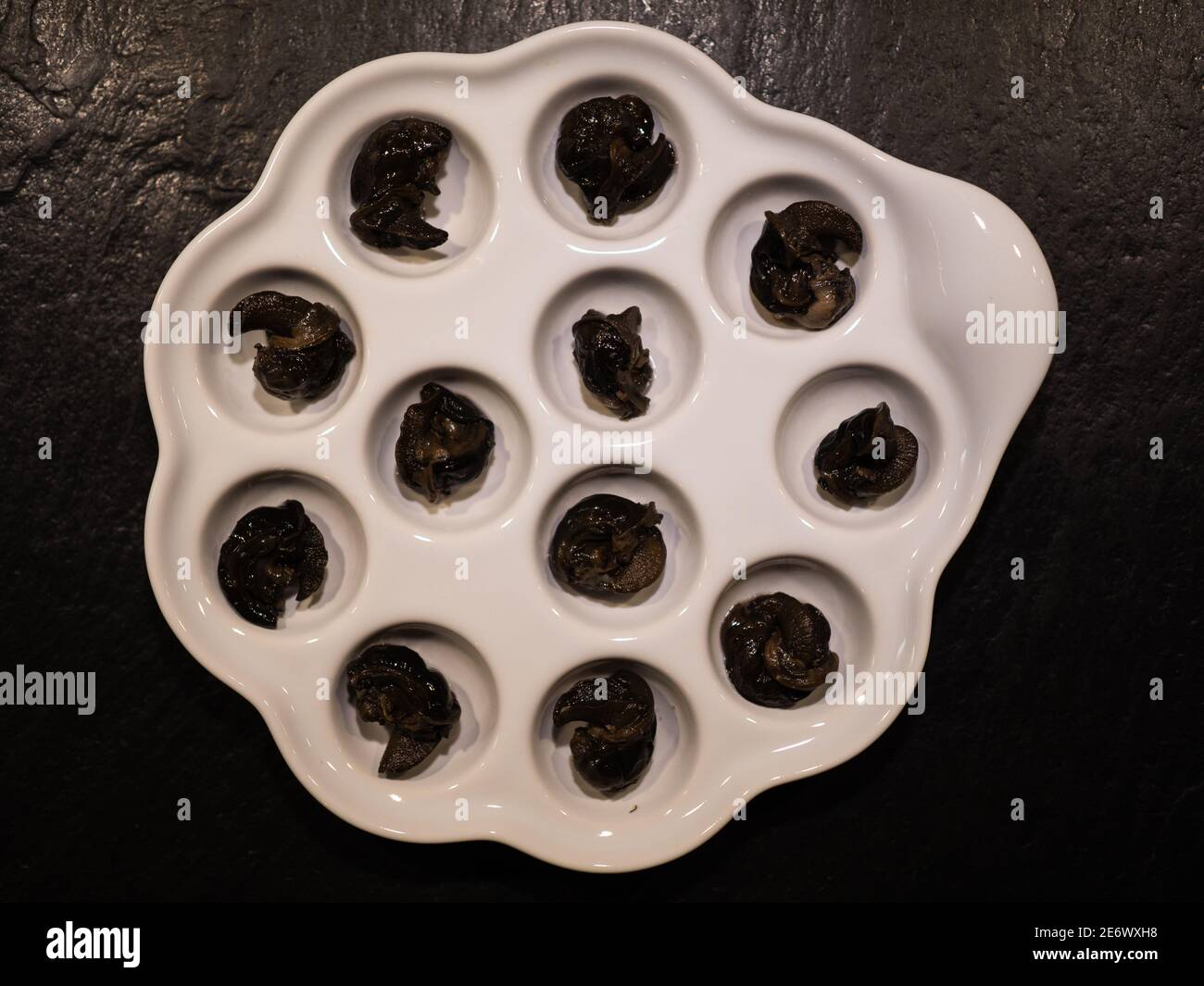 One dozen of snails on white plate. Flat lay, top view Stock Photo - Alamy