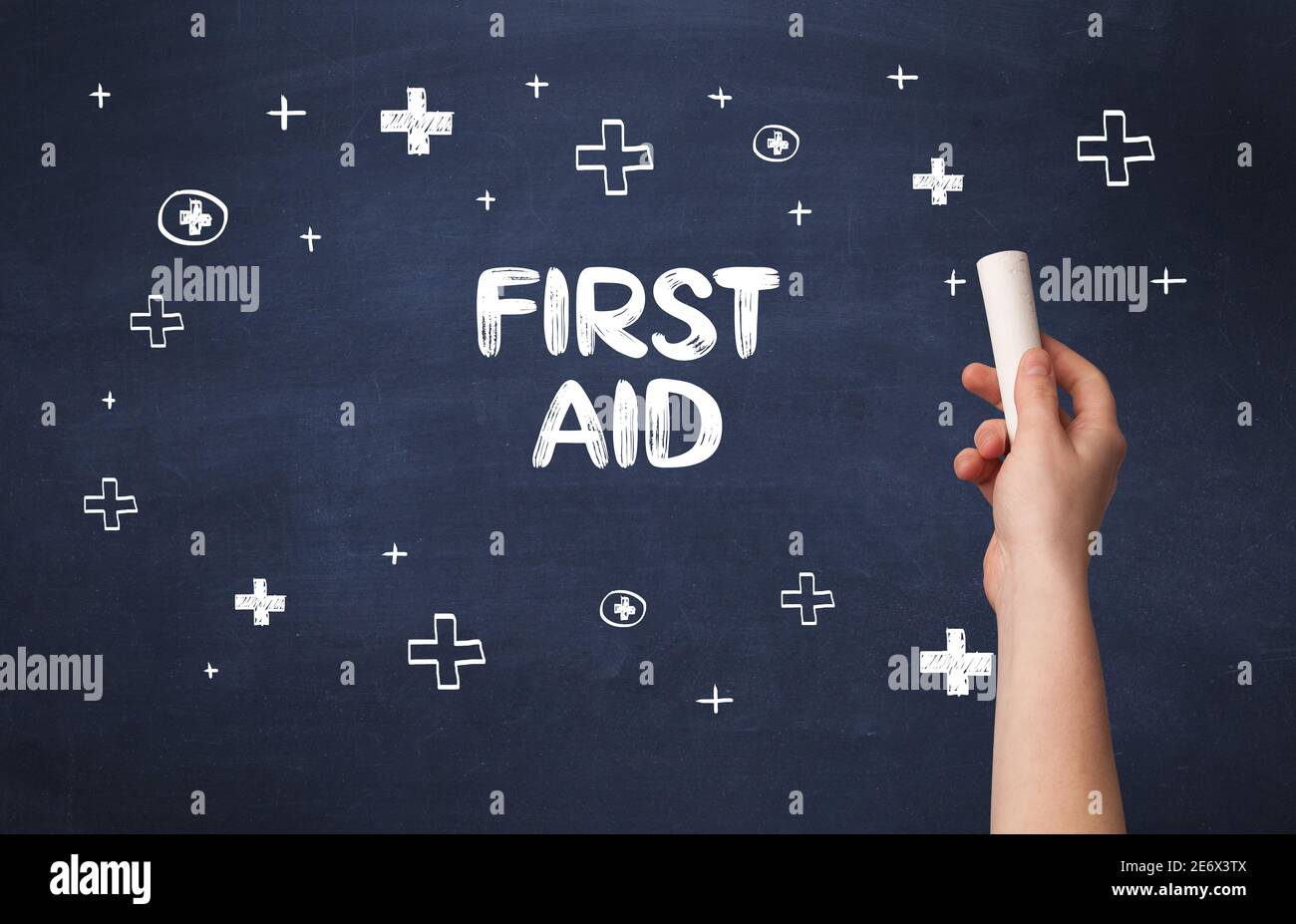 Hand drawing FIRST AID inscription with white chalk on blackboard ...