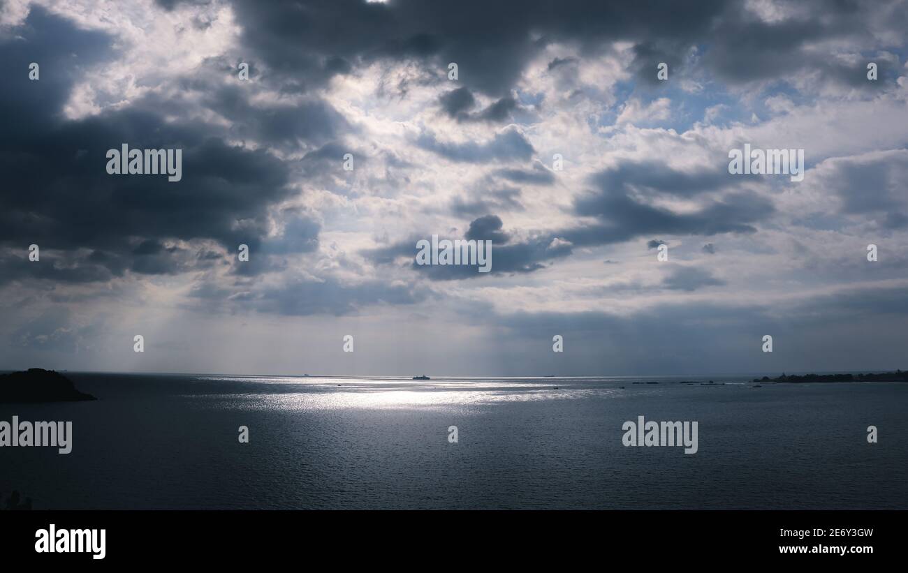 Sun rays coming out through the clouds and hitting the horizon, ocean ...