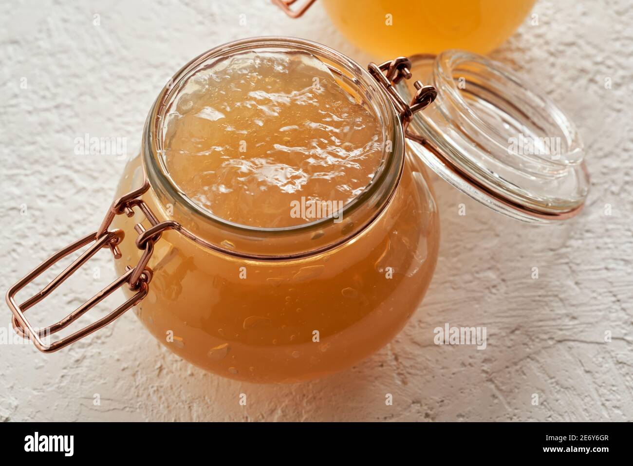Chilled jellied beef bone broth in a glass jar on a white background ...