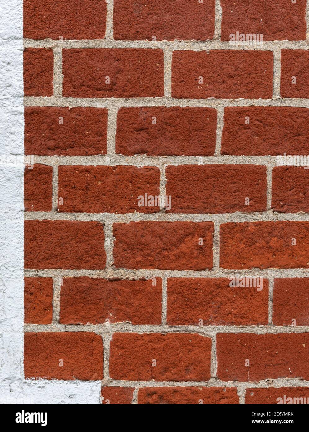 A red brick wall with a white painted border at left and bottom, a ...