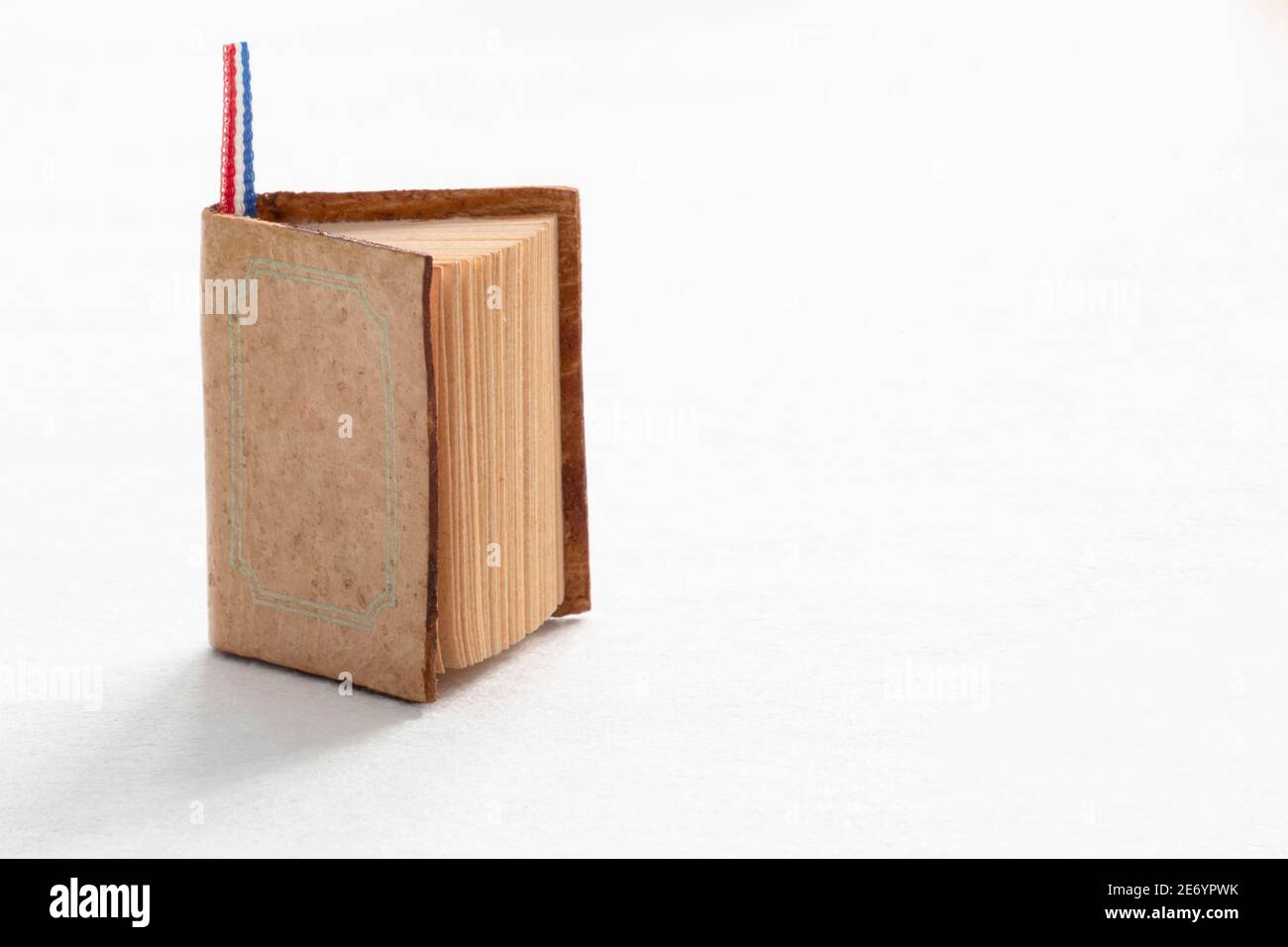 A book on the edge on a white background Stock Photo - Alamy