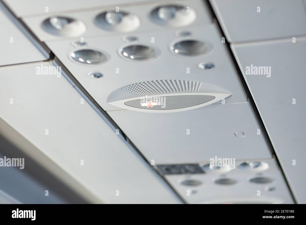 Gray ceiling inside aircraft with information panels, no smoking ...