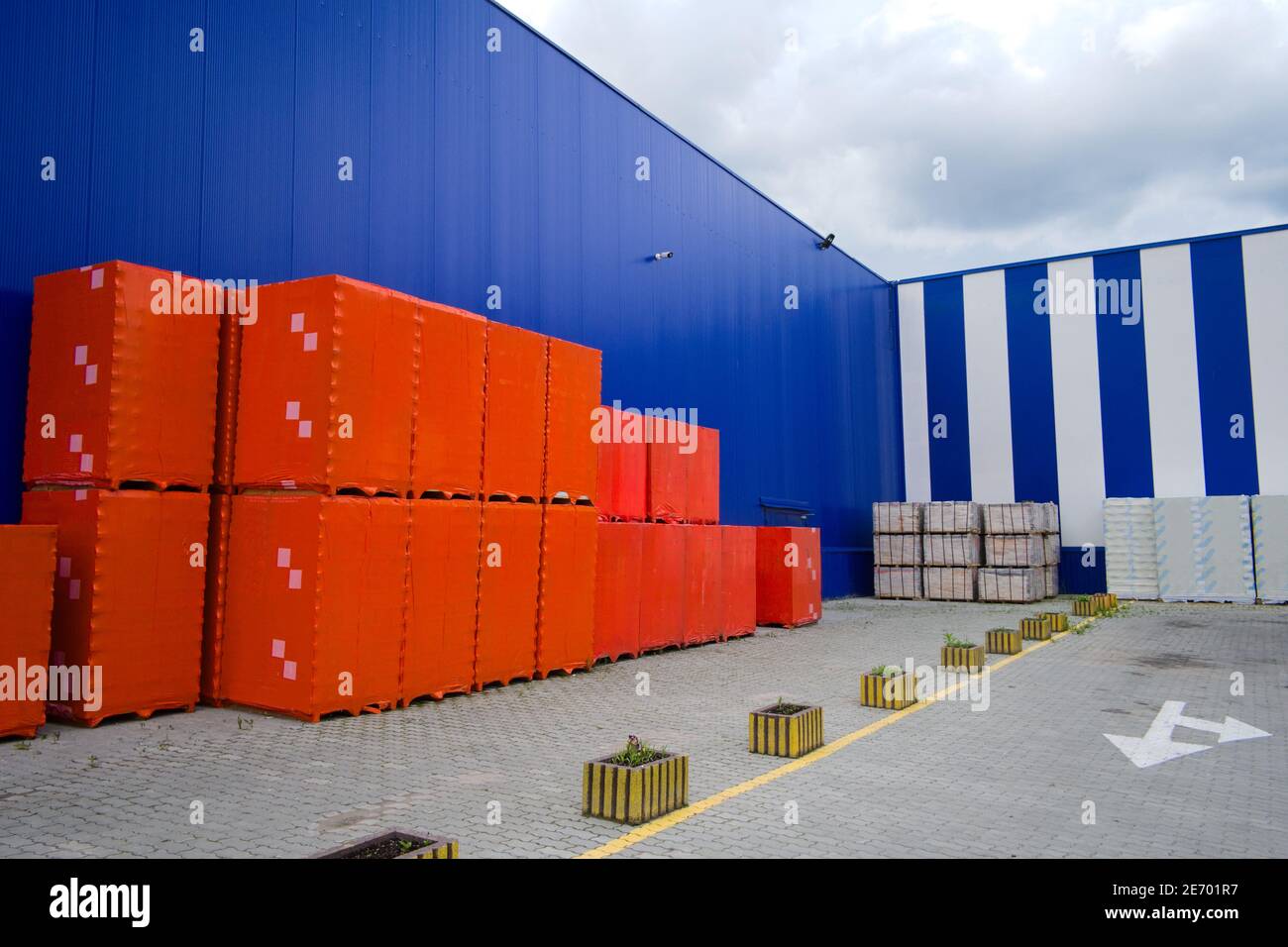 Bricks stack wrapped in orange stretched plastic near large hardware ...