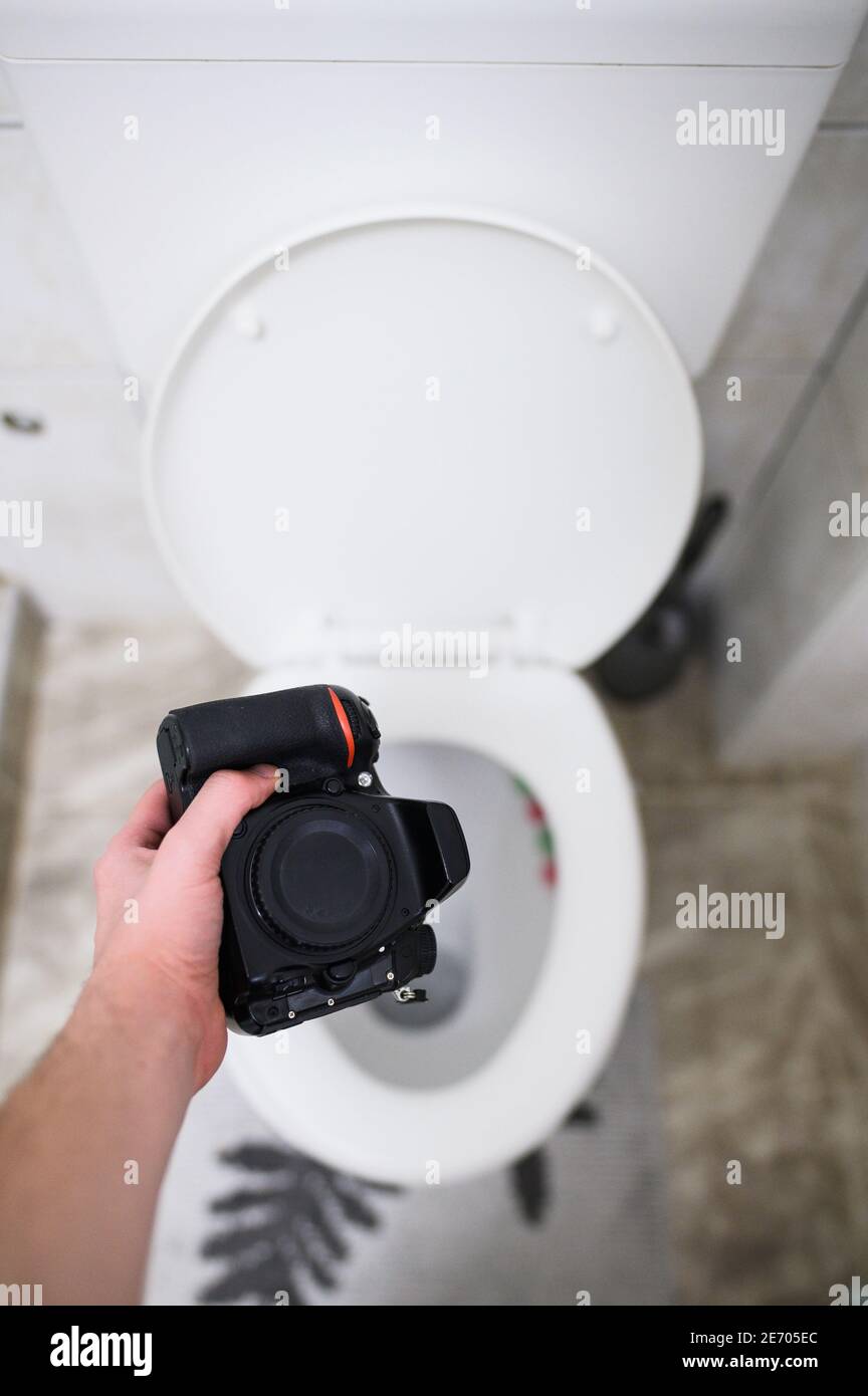 Vertical shot of a person holding a camera over the toilet Stock Photo ...
