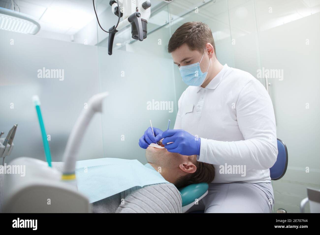 Professional dentist working at his clinic, treating teeth of male ...