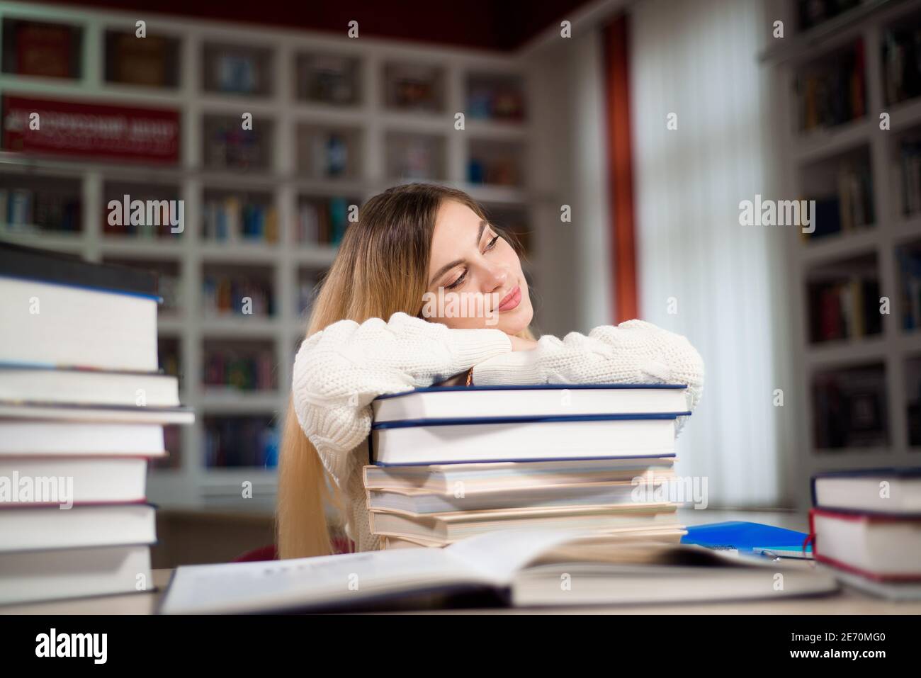 A tired student is studying in the school library Stock Photo - Alamy