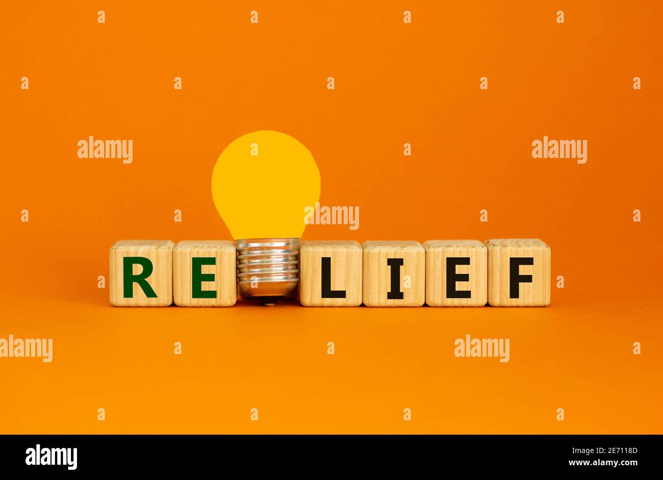 Relief symbol. Wooden cubes with word 'relief'. Yellow light bulb ...