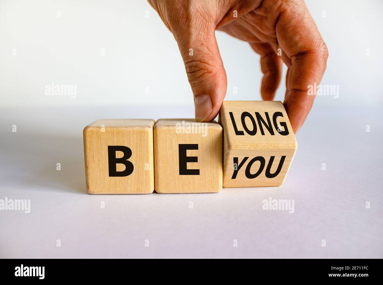 Be you, belong symbol. Businessman hand turns a cube and changes words ...