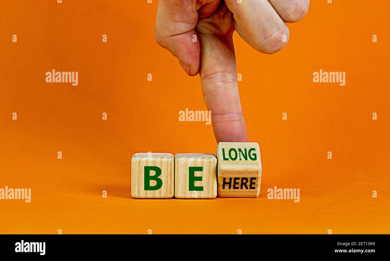 Be here belong symbol. Businessman hand turns a cube and changes words ...