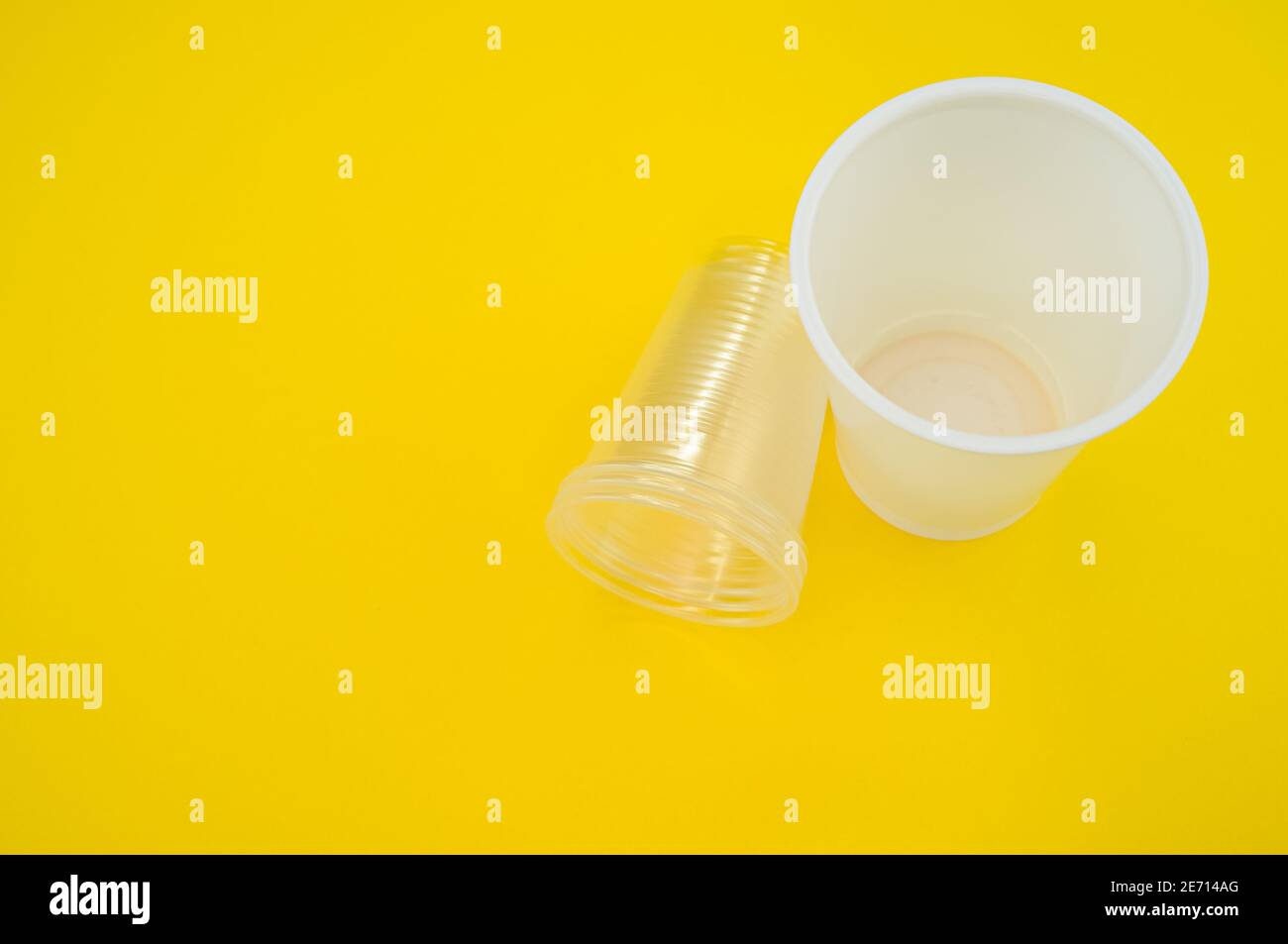 High angle shot of big and small plastic cups on a yellowsurface Stock ...