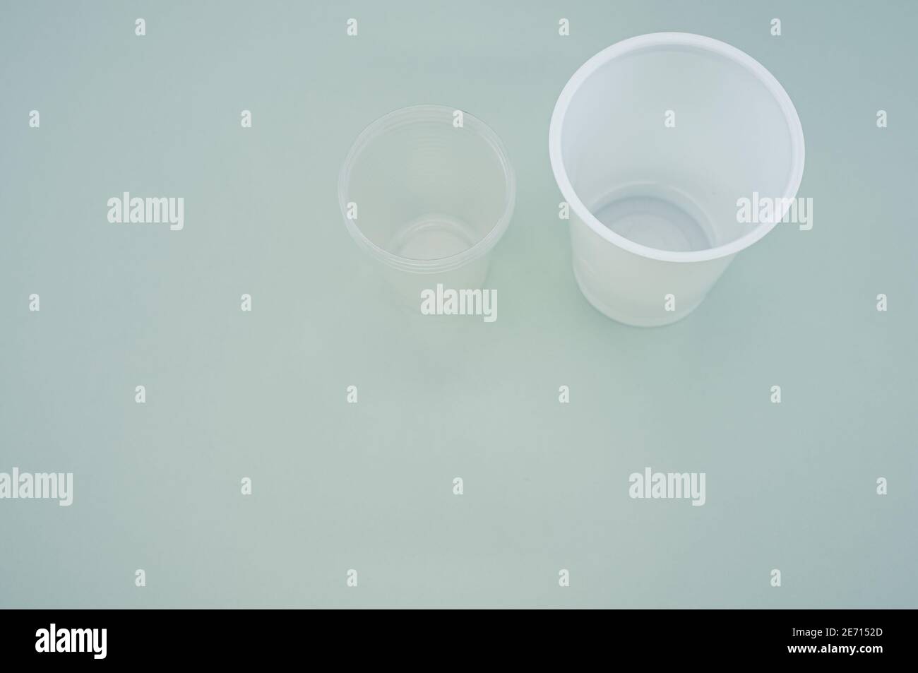 High angle shot of big and small plastic cups on a blue surface Stock ...